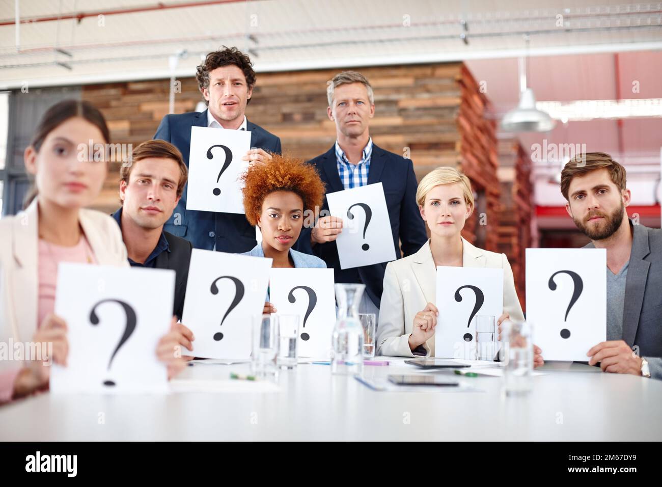 Any questions. Portrait of a group of businesspeople holding up cards ...
