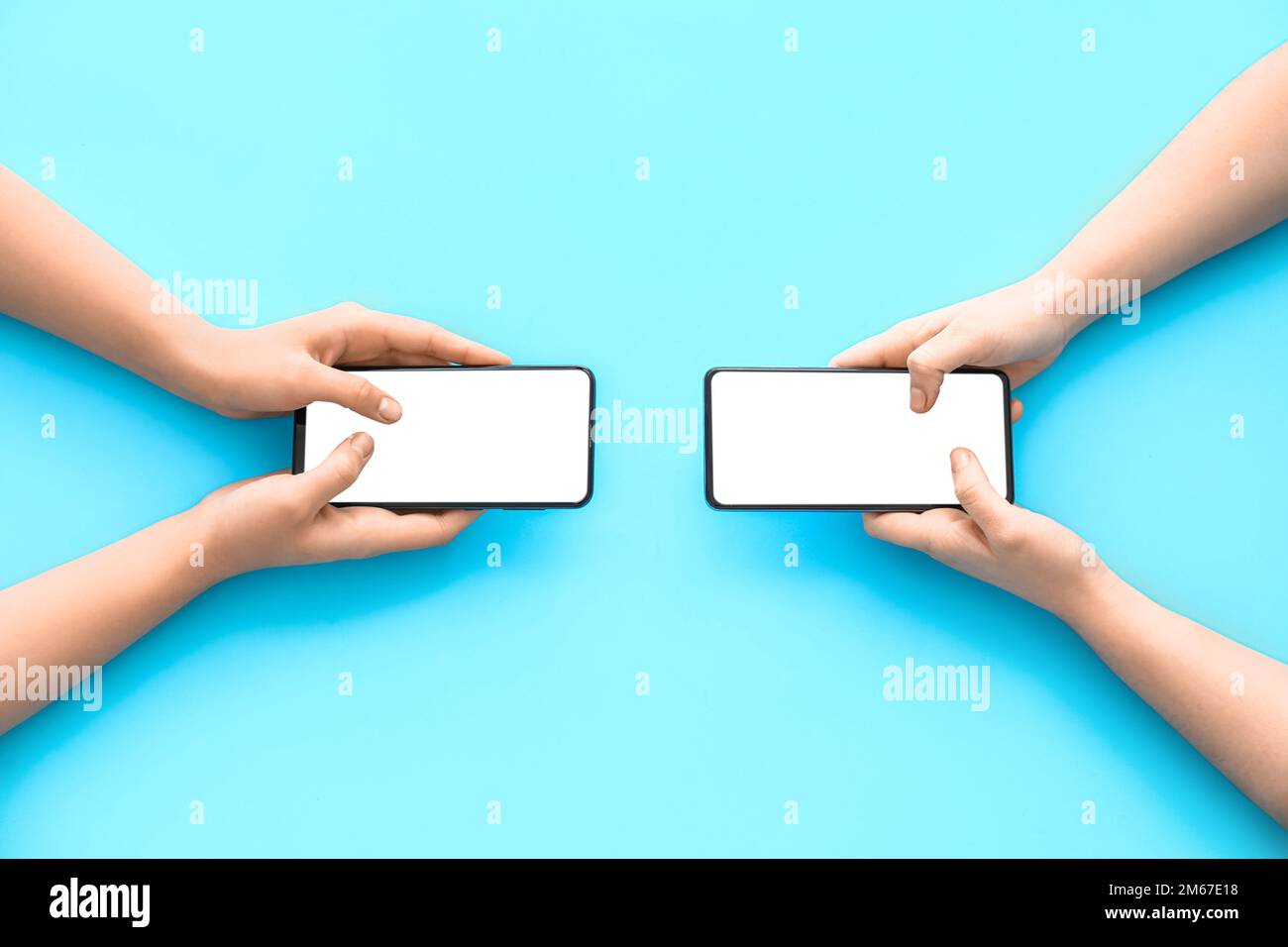 Female hands with modern mobile phones on blue background Stock Photo ...