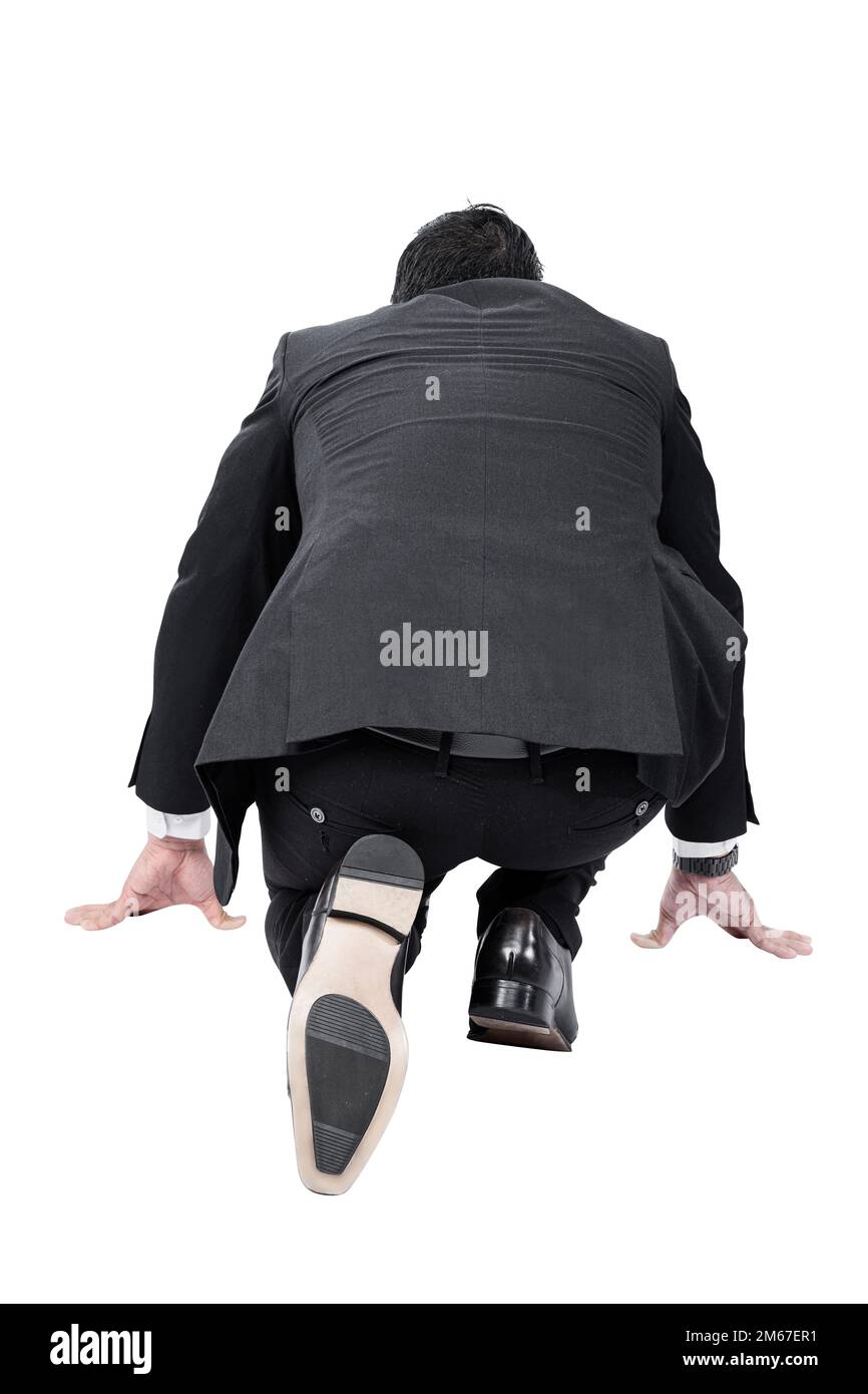 Rear view of Asian businessman in start position ready to run isolated ...