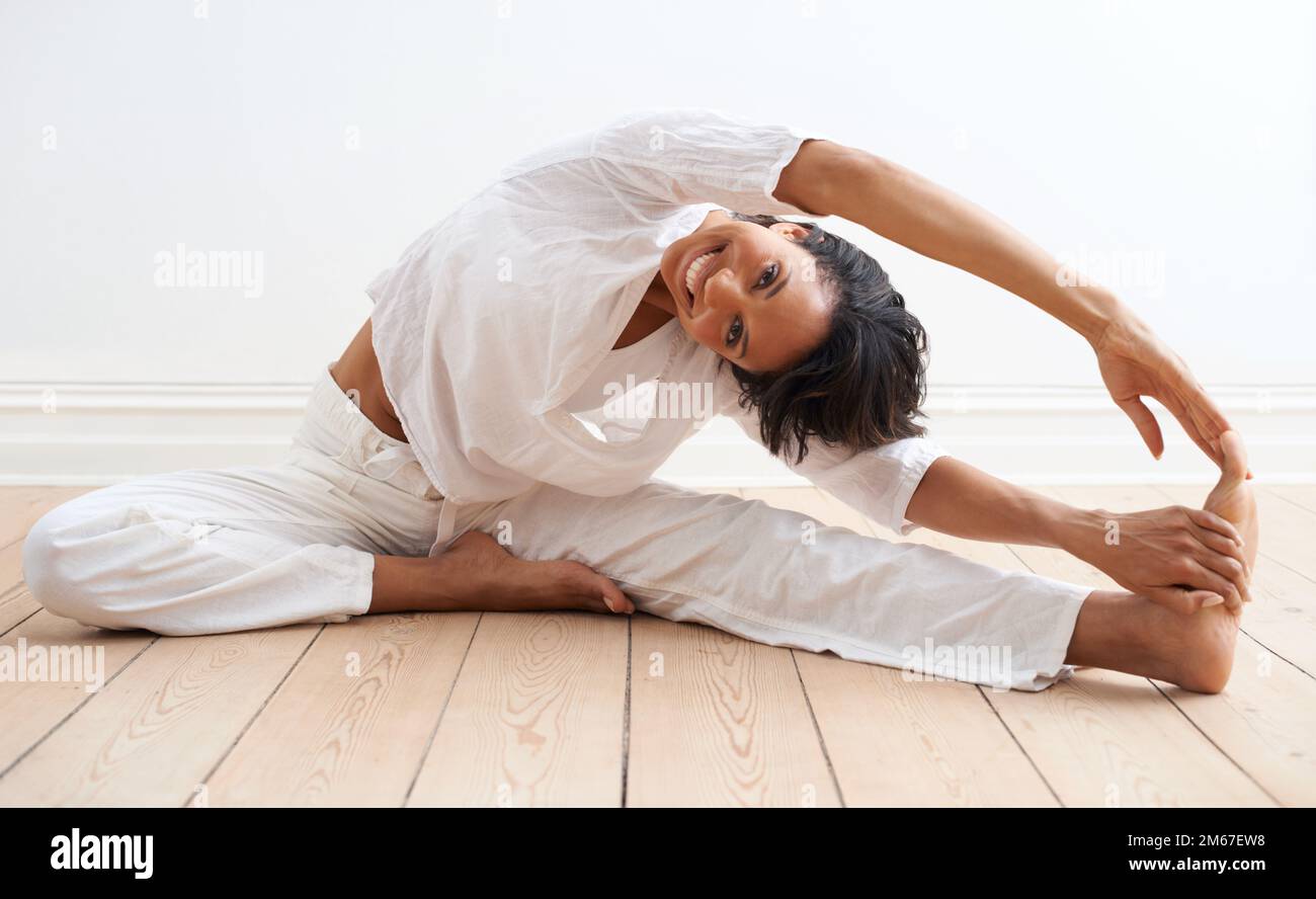Limber and invigorated. A pretty young woman doing stretches before a ...