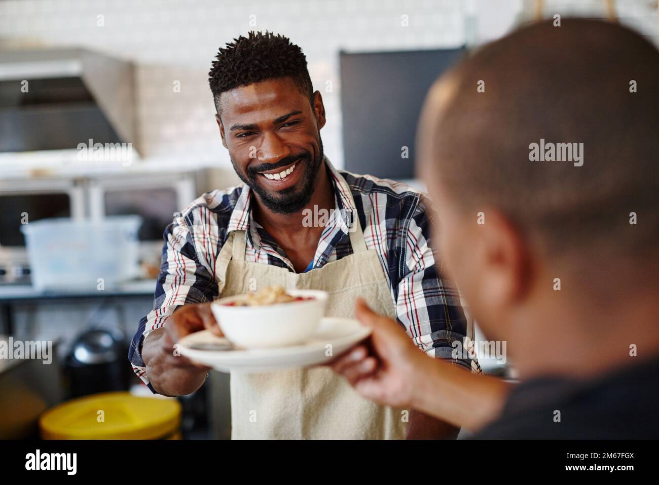 Here you go, sir, enjoy. a young man serving a customer at a cafe Stock ...