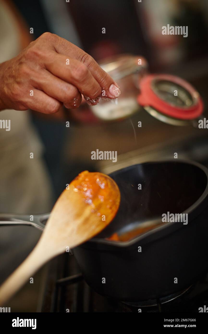 Seasoned with salt. Closeup shot of a woman adding salt to the pot on ...