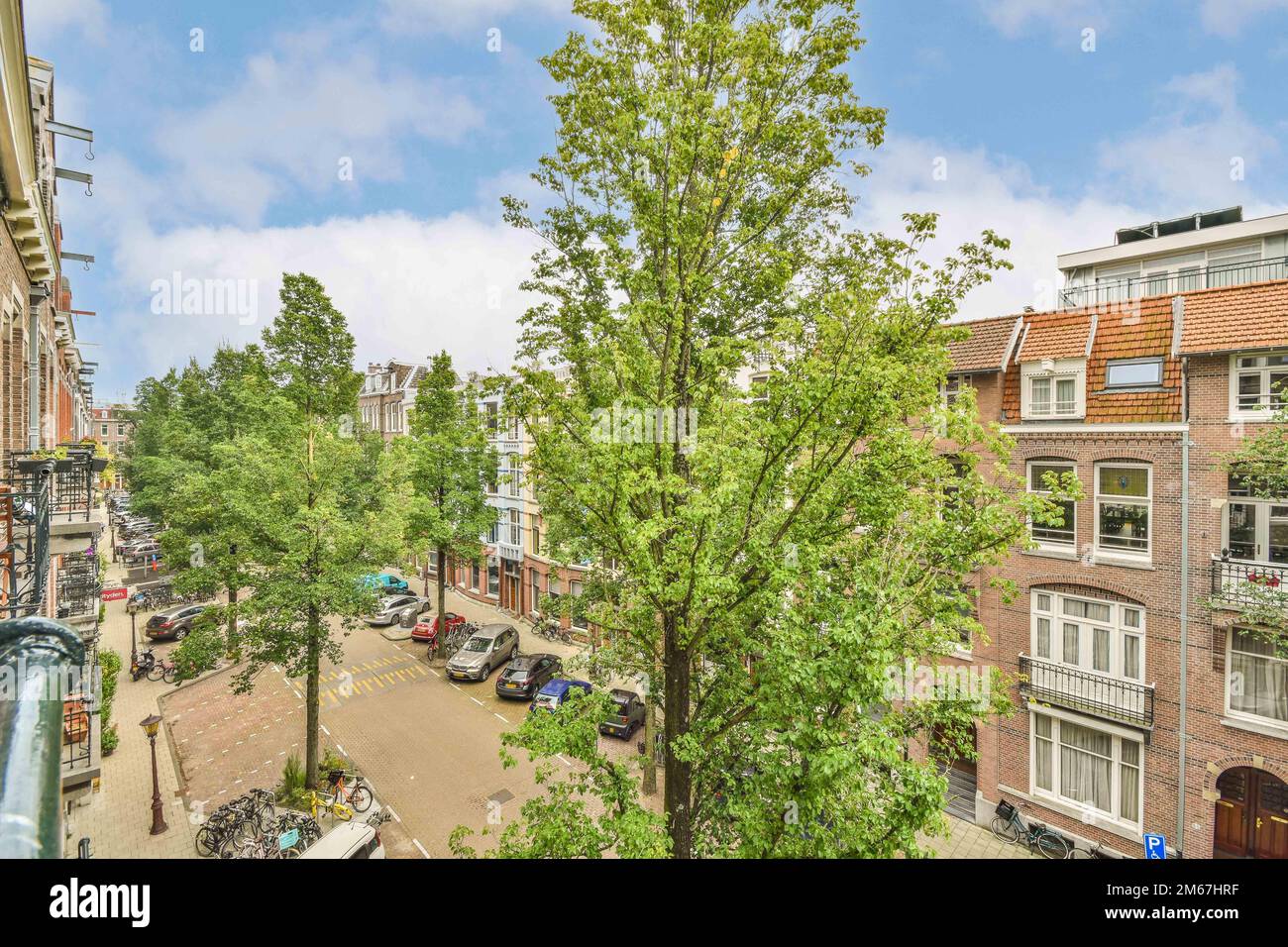 an empty street in the middle of amsterdam, with cars parked on both ...