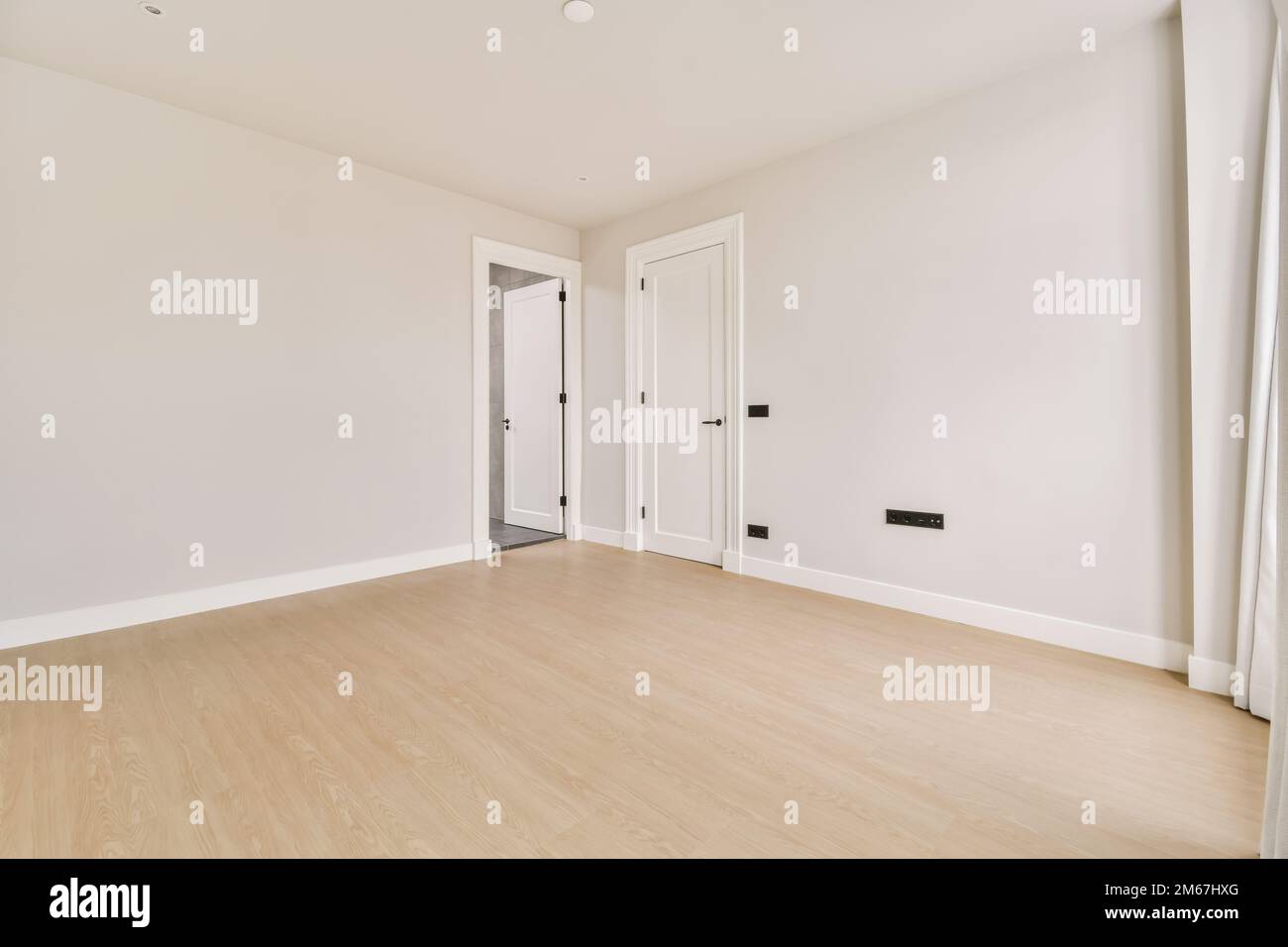 an empty room with white walls and wood flooring on the right, there is ...