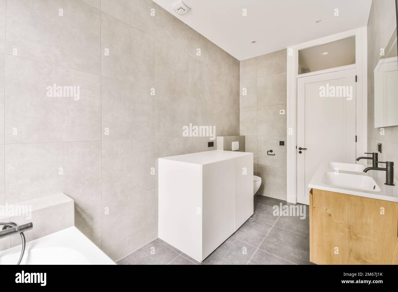a modern bathroom with grey tile flooring and white fixtures on the ...