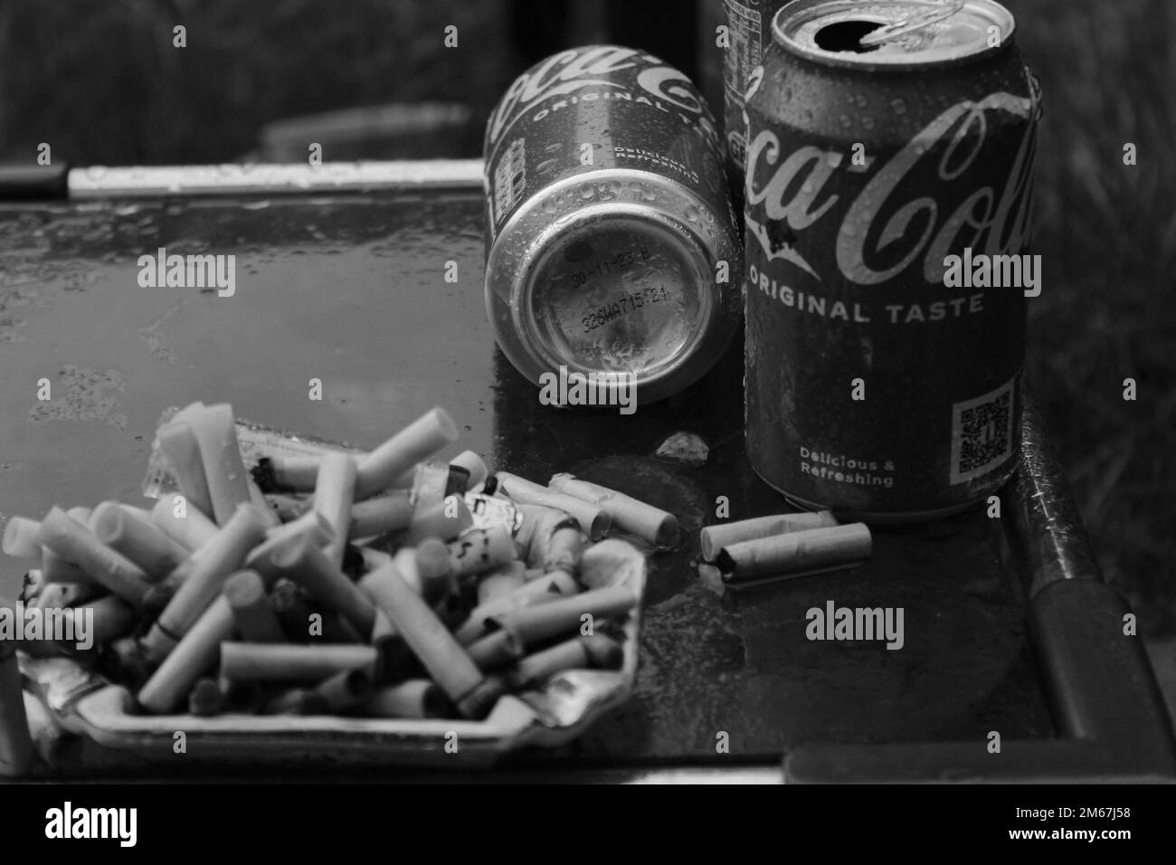 A greyscale shot of an empty Coca-Cola soaked in the rain Stock Photo ...