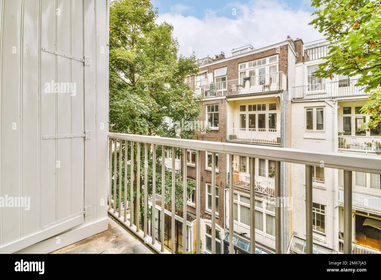 a balcony with trees and buildings in the background, taken from an ...