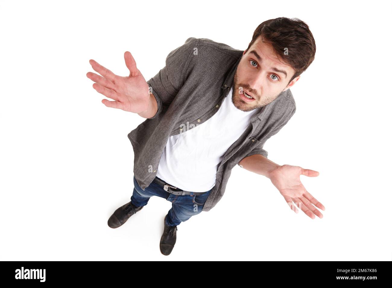 It wasnt me. High-angle shot of a young man in studio holding up his ...