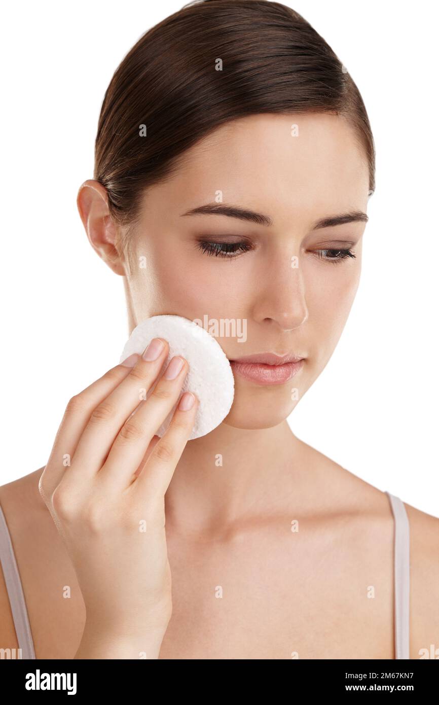 Maintaing her perfect skin. a beautiful young woman exfoliating her ...