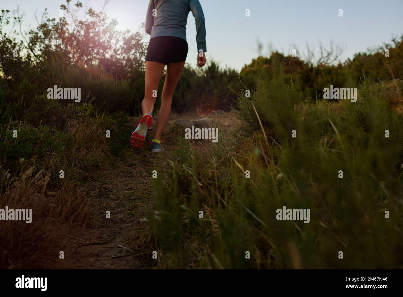One step at a time. Low angle shot of a young woman running outdoors ...