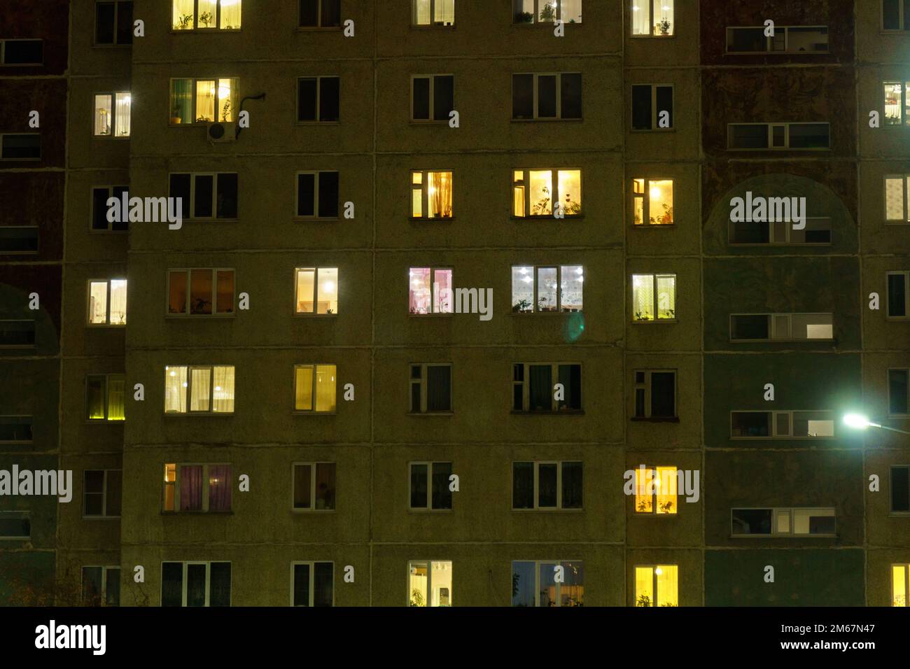 Night windows of a multi-storey building. Luminous and dark windows in ...