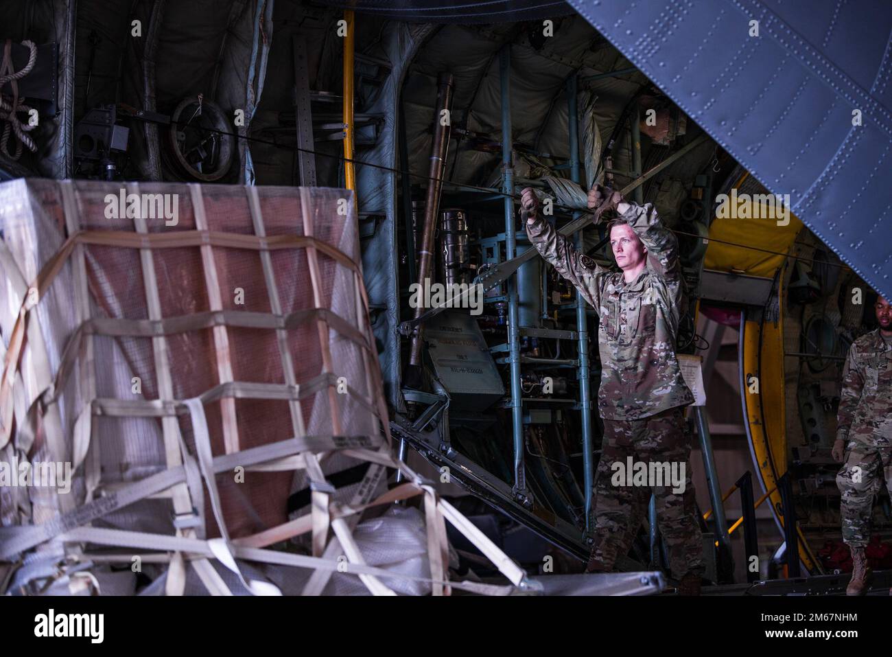 Staff Sgt. Tyler Pitts, a student in the Basic Loadmaster Course, directs cargo into the static ...