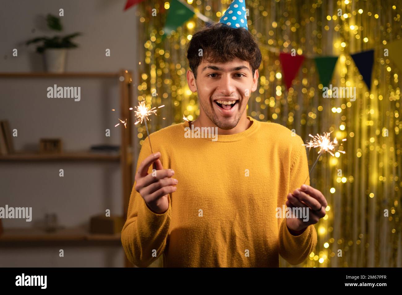 Arab man having birthday joy at home with sparklers Stock Photo - Alamy