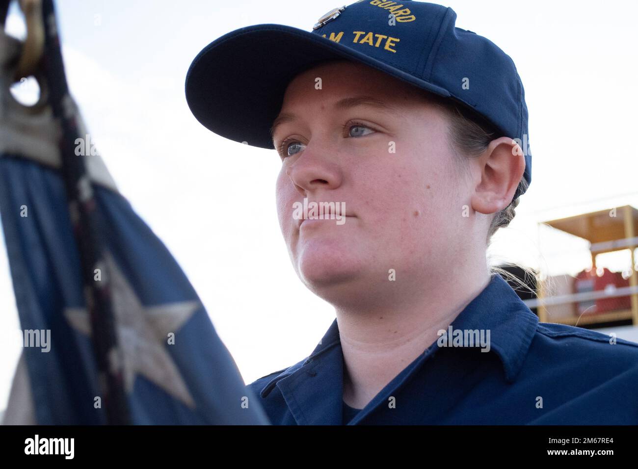 Coast Guard Seaman Michela Quist hoists the flag during morning colors ...