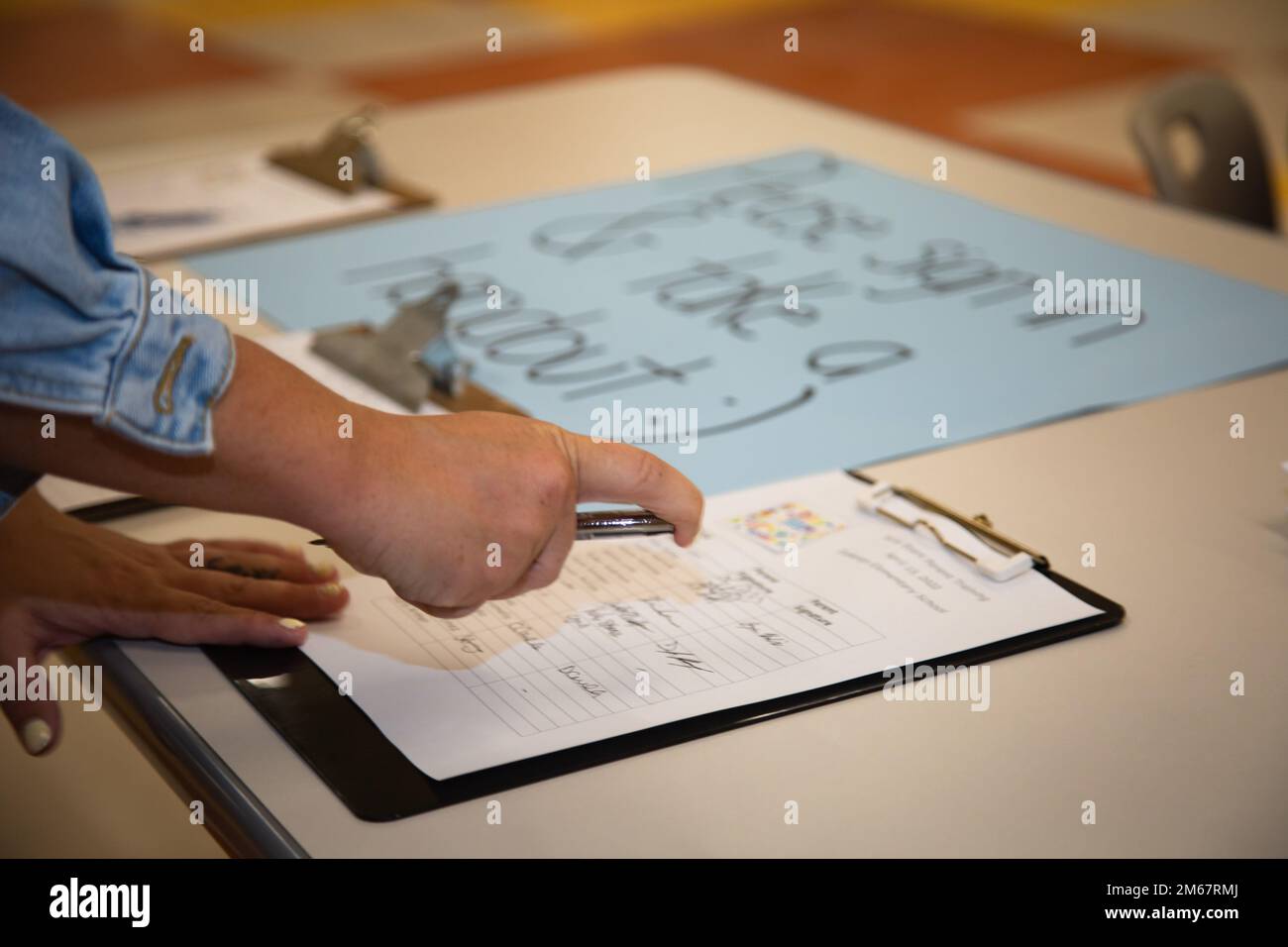 A parent signs her name on a roster prior to the Sure Start’s ...