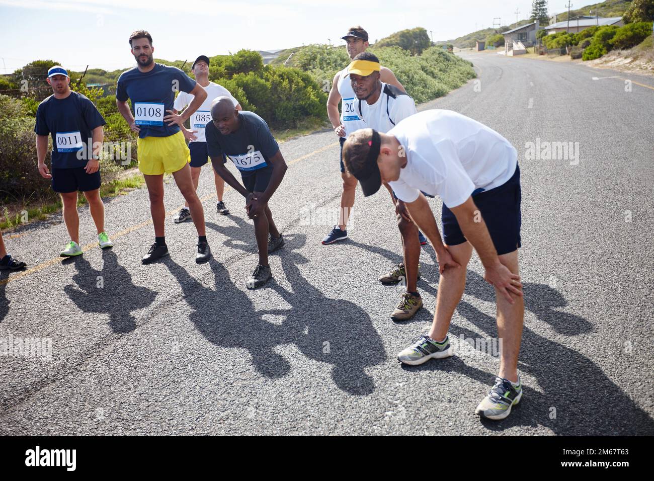 Mind over matter. a group of male runners getting focused before a road ...