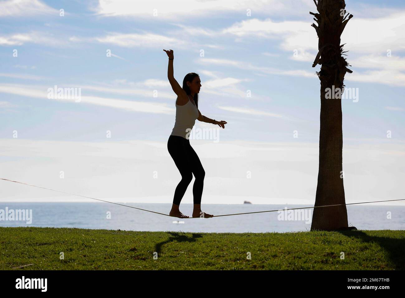 Silhouette of girl walking on a slack line in Malaga, Spain, Europe ...