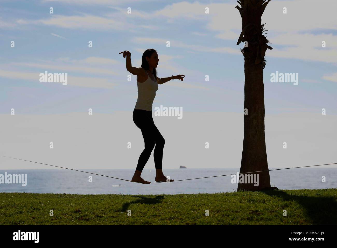 Silhouette of girl walking on a slack line in Malaga, Spain, Europe ...