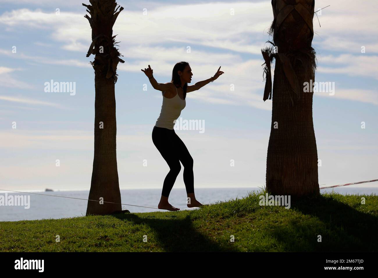 Silhouette of girl walking on a slack line in Malaga, Spain, Europe ...