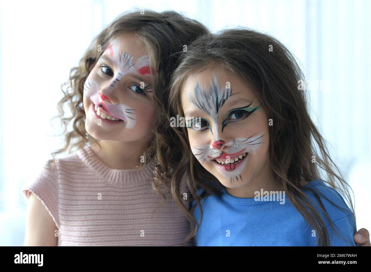 Cute little girls with faces painted posing Stock Photo - Alamy