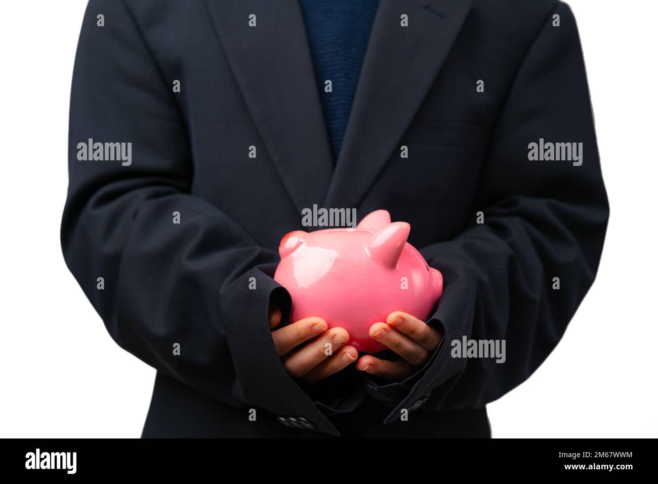 Close up of young entrepreneur in adult suit holding piggy bank ...
