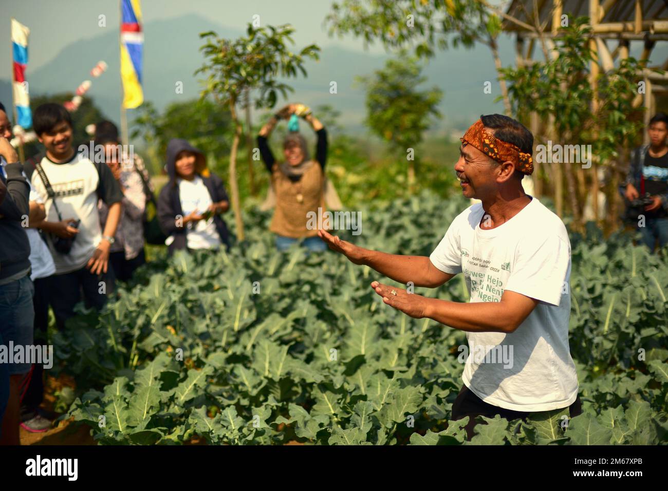 A farmer giving explanation on organic farming to visitors as they are ...