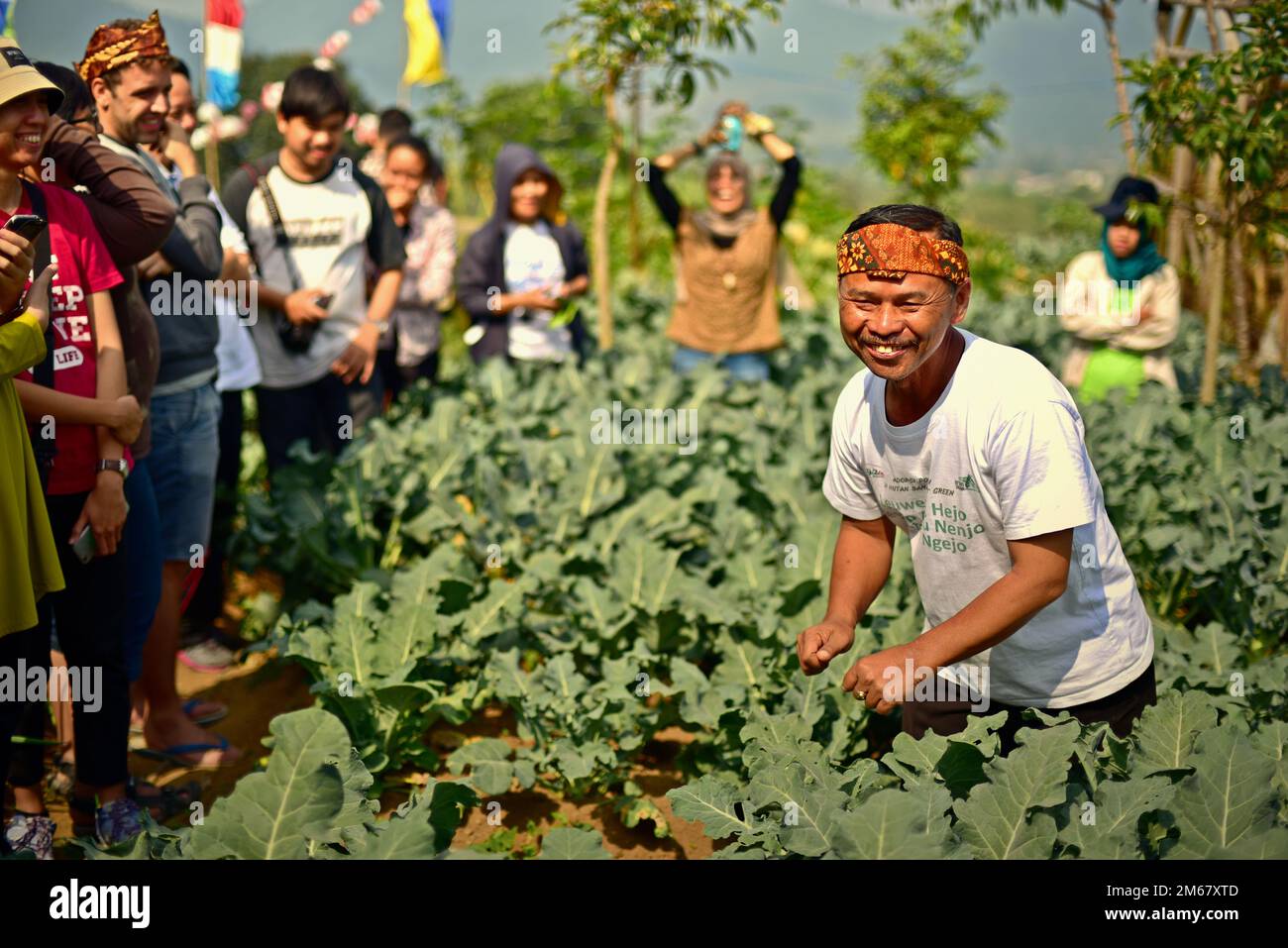 A farmer giving explanation on organic farming to visitors as they are ...