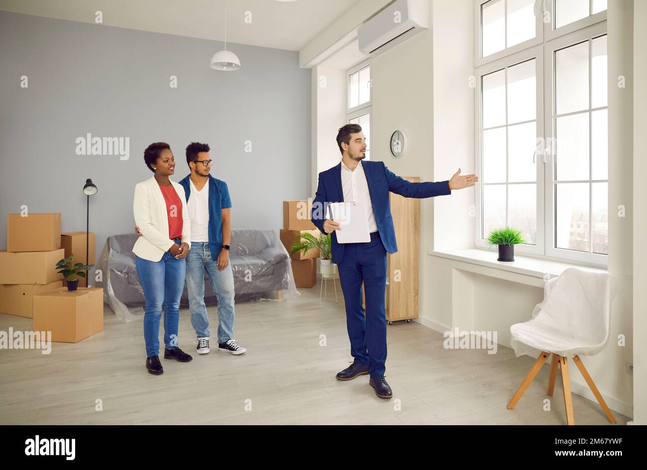 Man realtor show house to multiethnic couple clients Stock Photo - Alamy