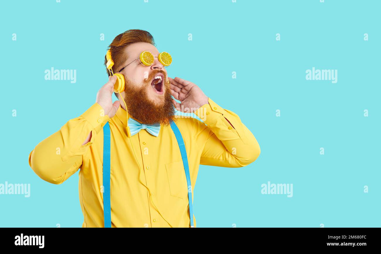 Funny stylish fat man in headphones listens to music and sings loudly ...