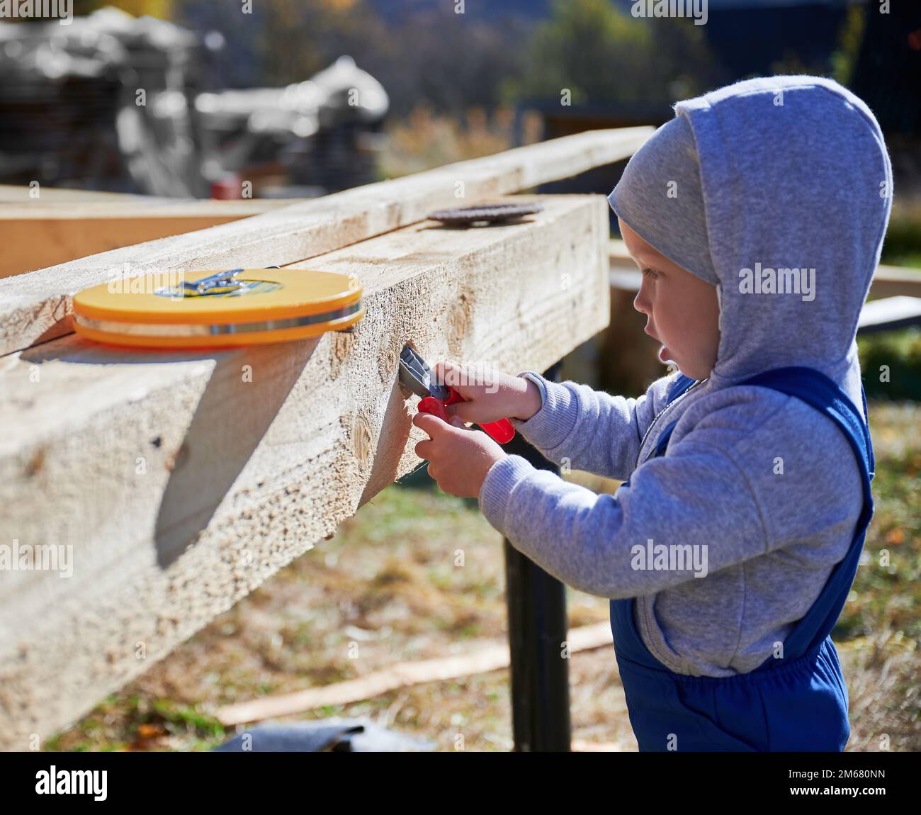 Boy toddler playing as builder on construction site. Child carpenter in ...