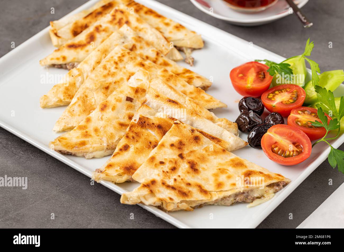Traditional Turkish flatbread or Gozleme with tomatoes, olives and tea ...