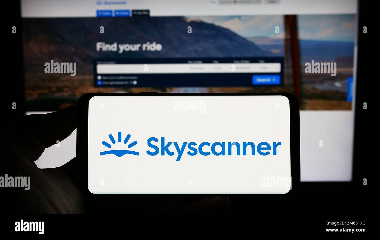 Person holding cellphone with logo of travel metasearch company ...