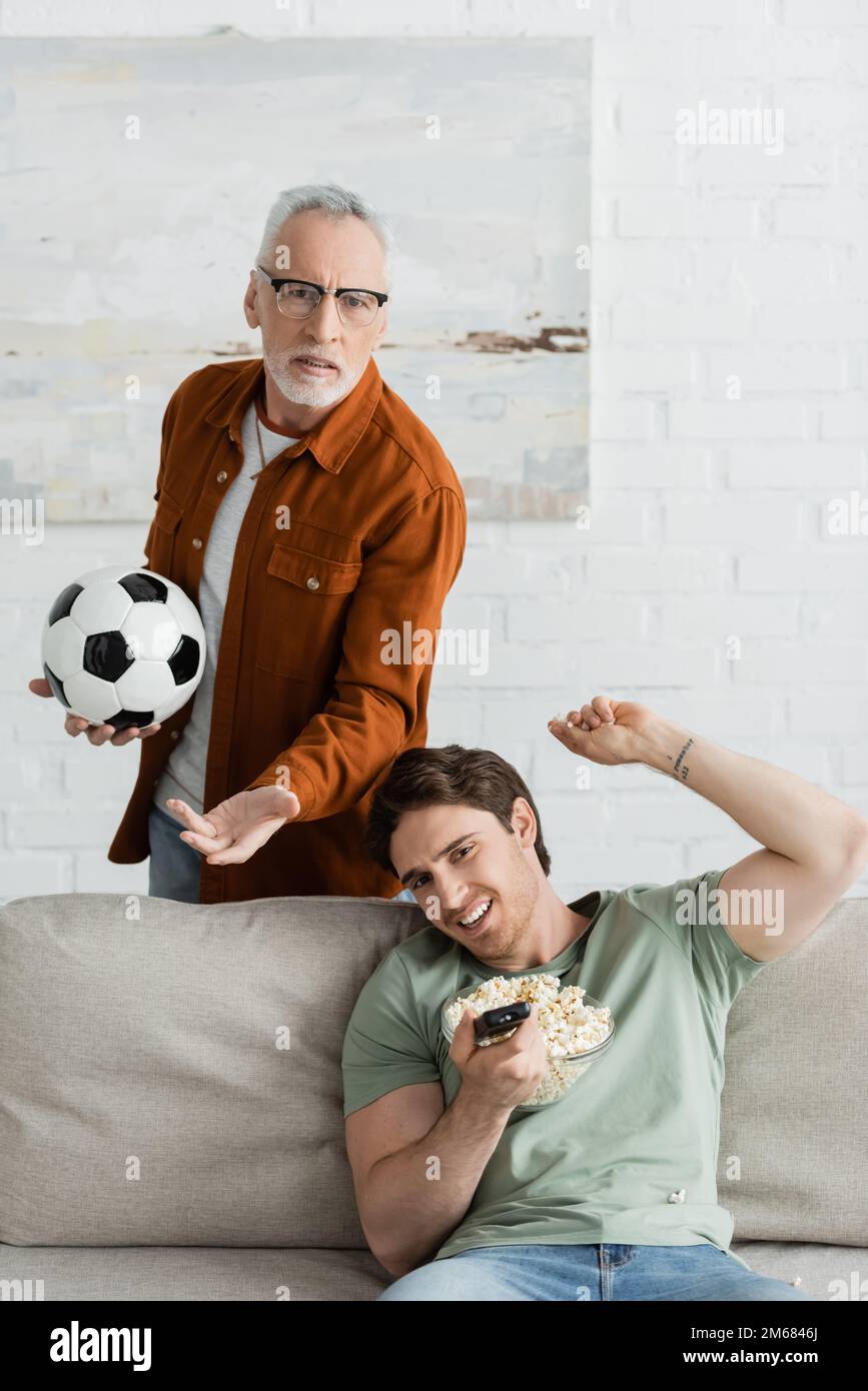 Frustrated Father And Son With Soccer Ball And Bowl Of Popcorn