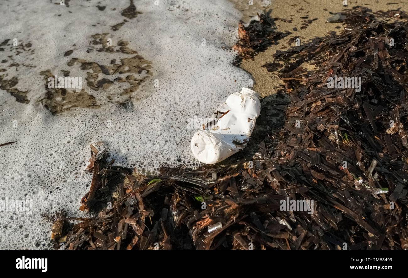 Plastic bottle trash floating over sea waves on contaminated beach ...