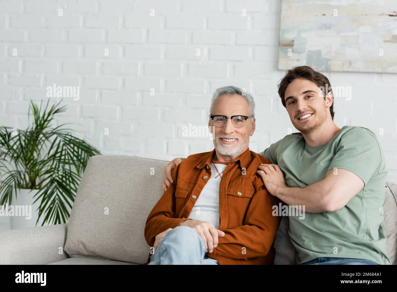 Father hugging son on couch hi-res stock photography and images - Alamy