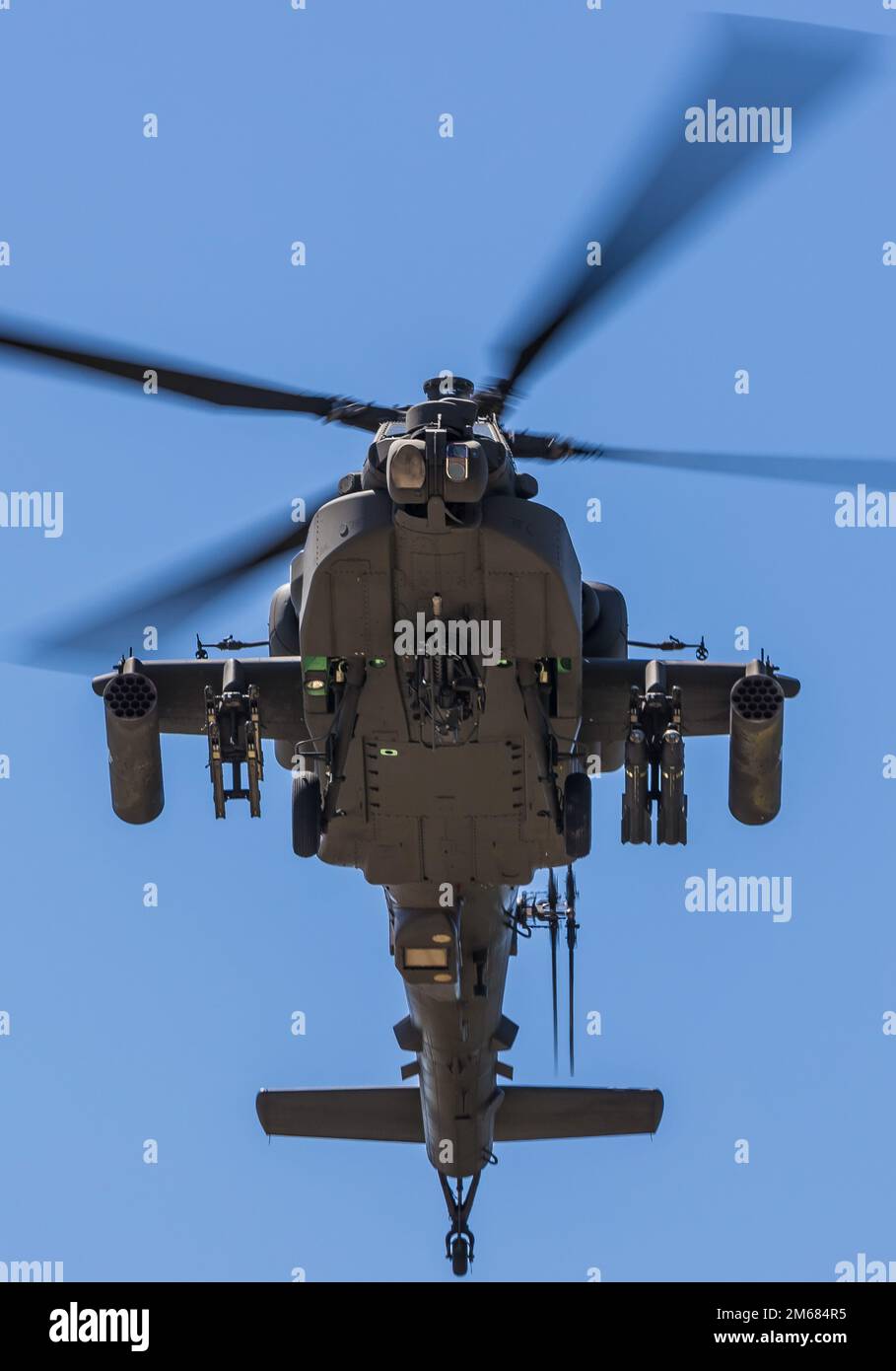 An AH-64 Apache helicopter flies overhead during an aerial gunnery ...