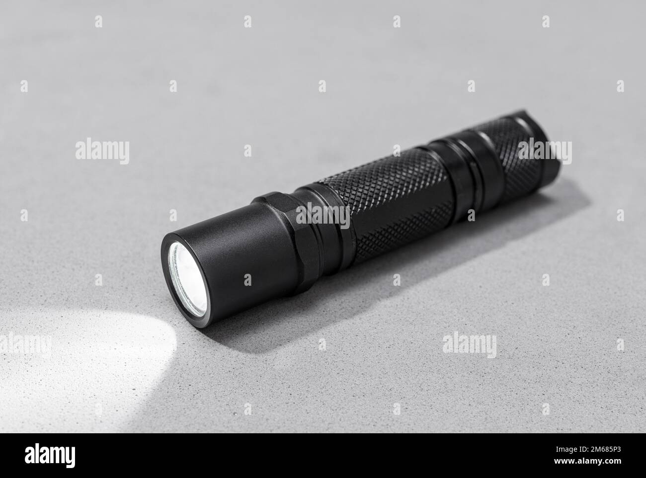 Modern aluminum Led Pocket Flashlight switch on isolated on gray ...