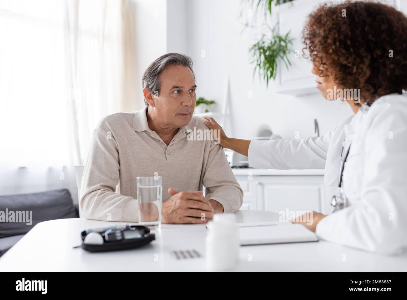 curly african american doctor calming middle aged man with diabetes ...