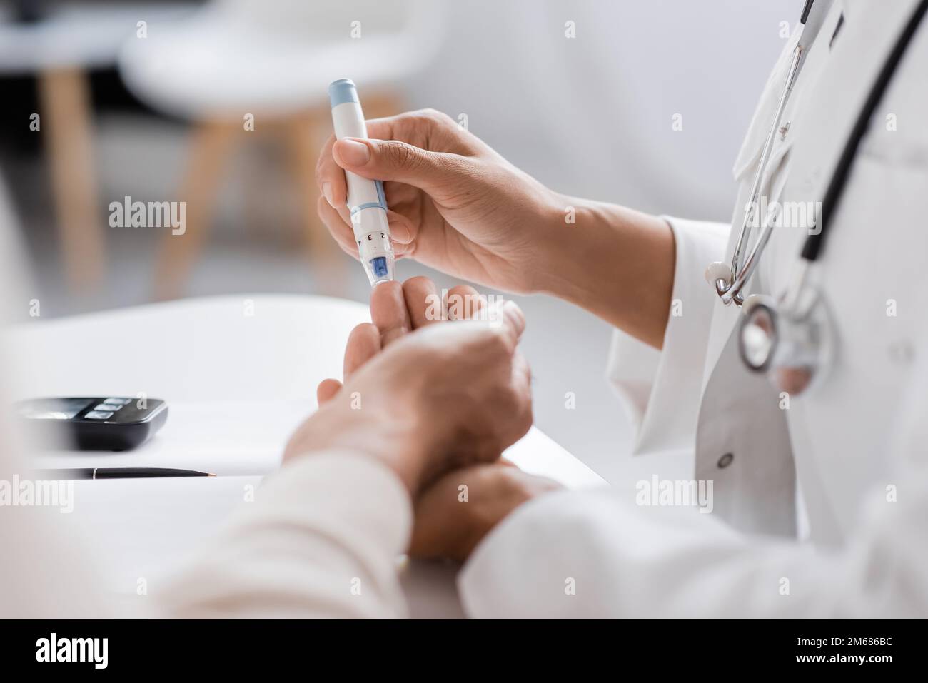 cropped view of african american doctor with stethoscope taking blood ...