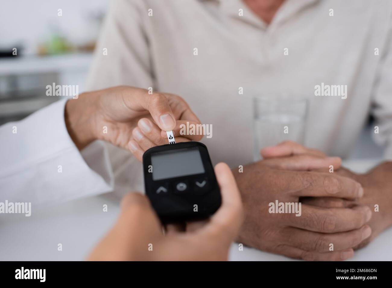 partial view of african american doctor showing test strip on ...