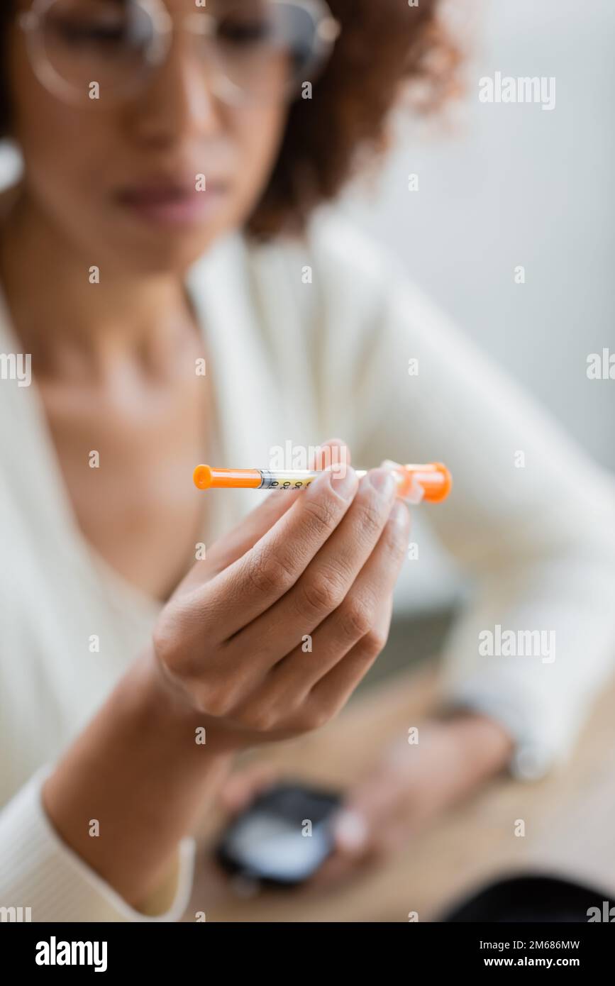 Blurred african american businesswoman with diabetes holding insulin ...