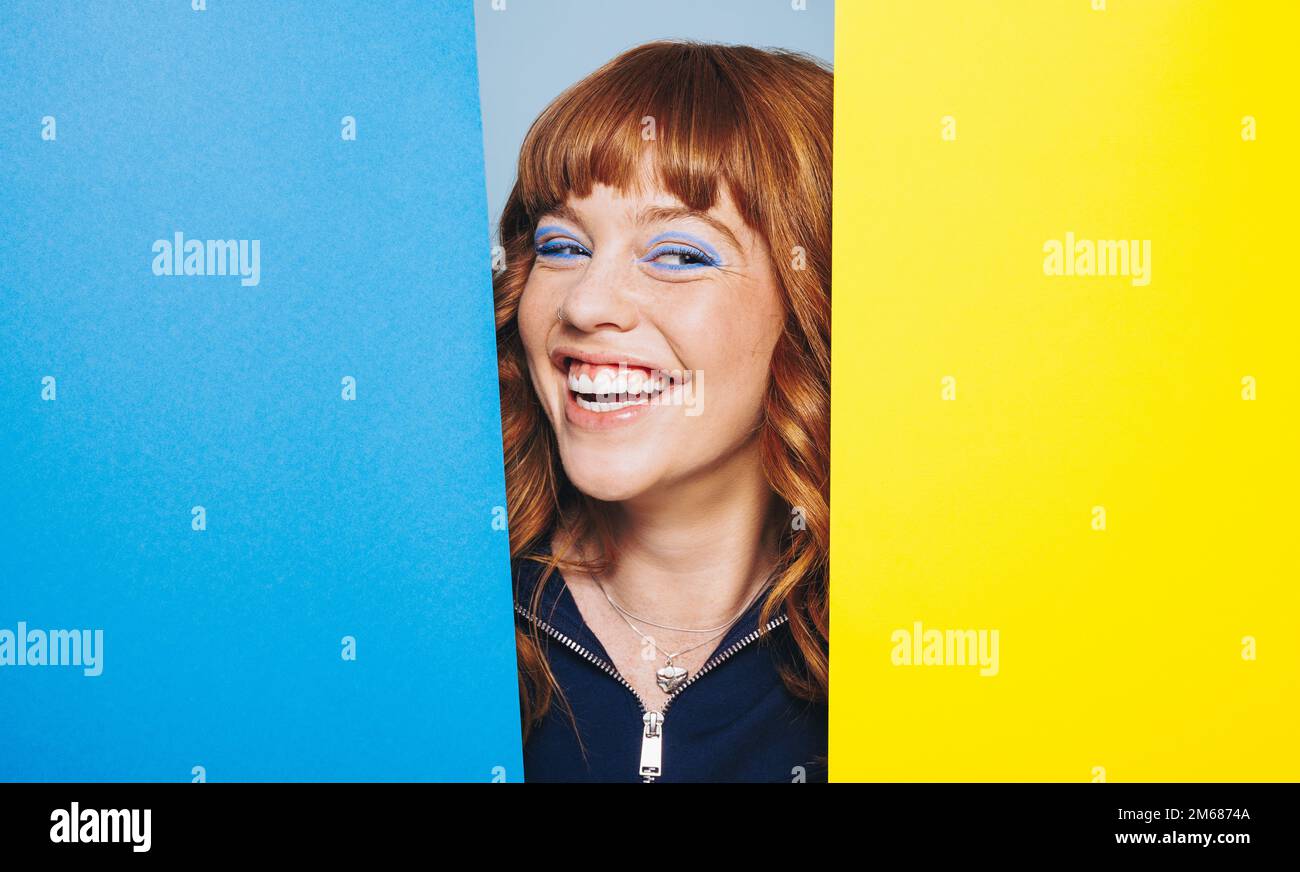 Happy woman standing with two colourful design shapes. Woman with ...