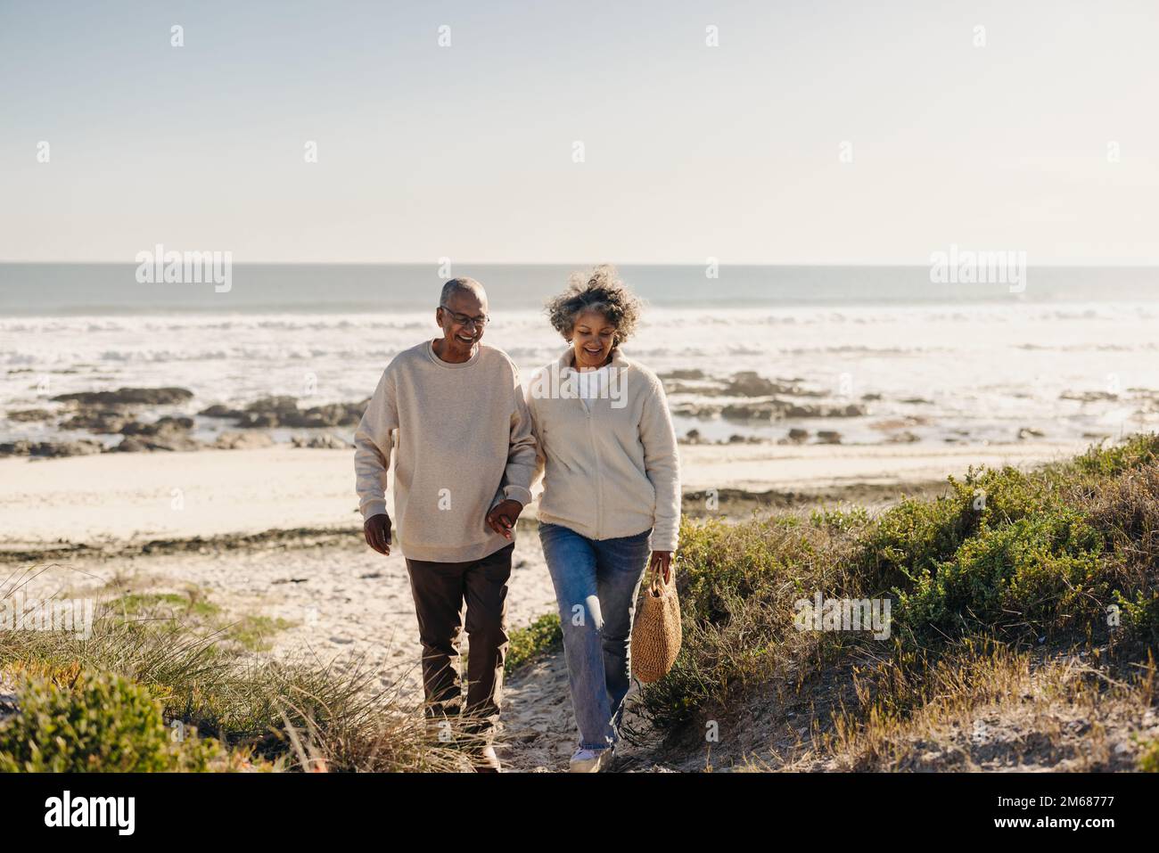Cheerful elderly couple smiling happily while walking away from the ...