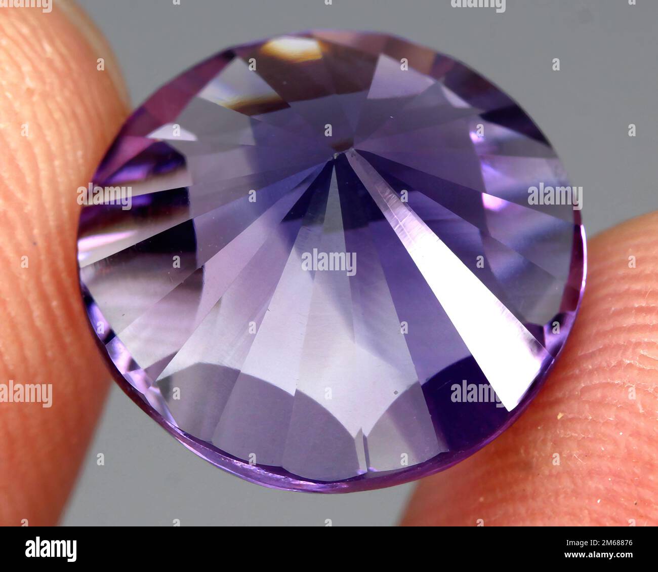 Natural stone purple amethyst on gray background Stock Photo - Alamy