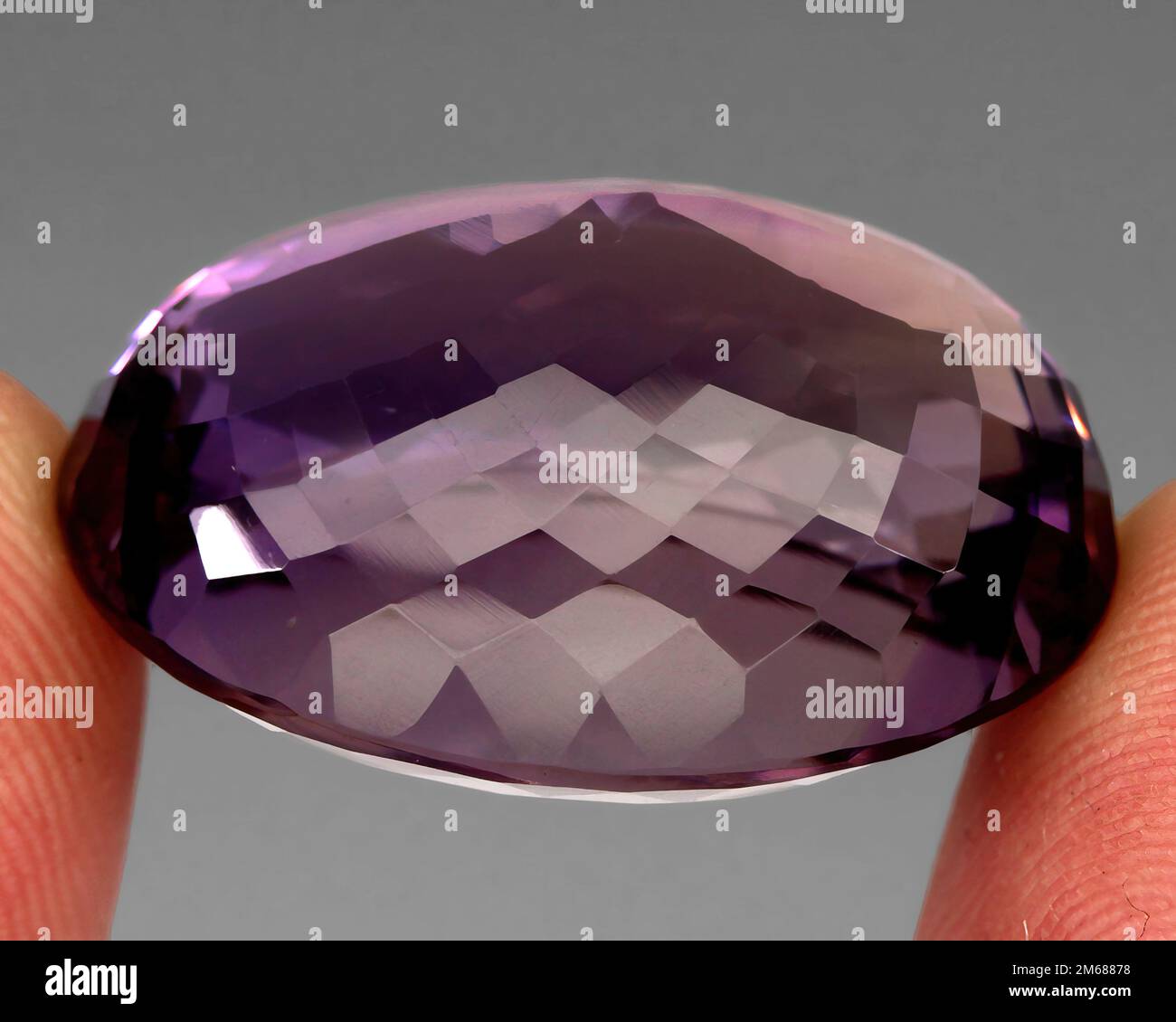 Natural stone purple amethyst on gray background Stock Photo - Alamy