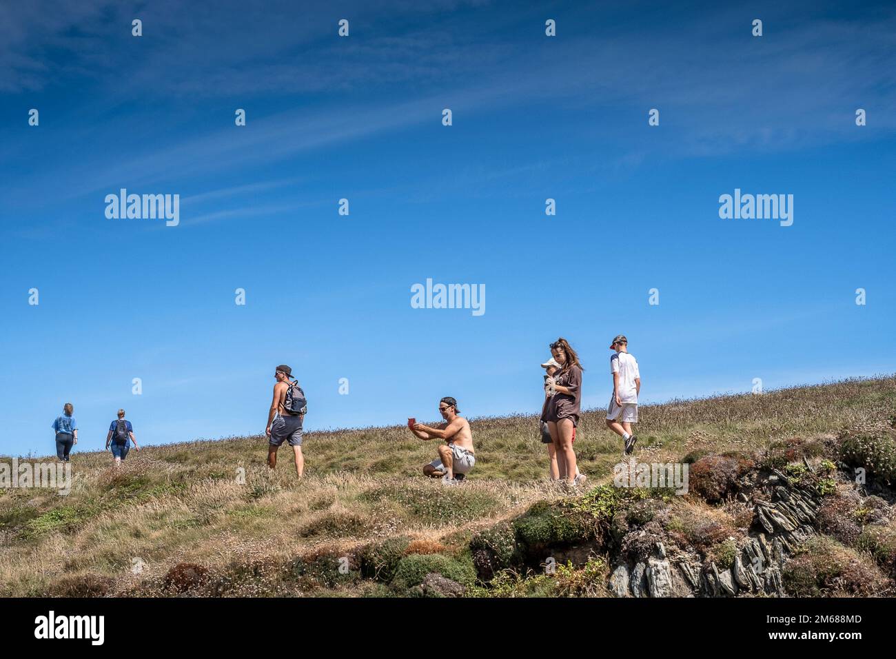 Tourists Holidaymakers Visitors walking on the coast path on West ...