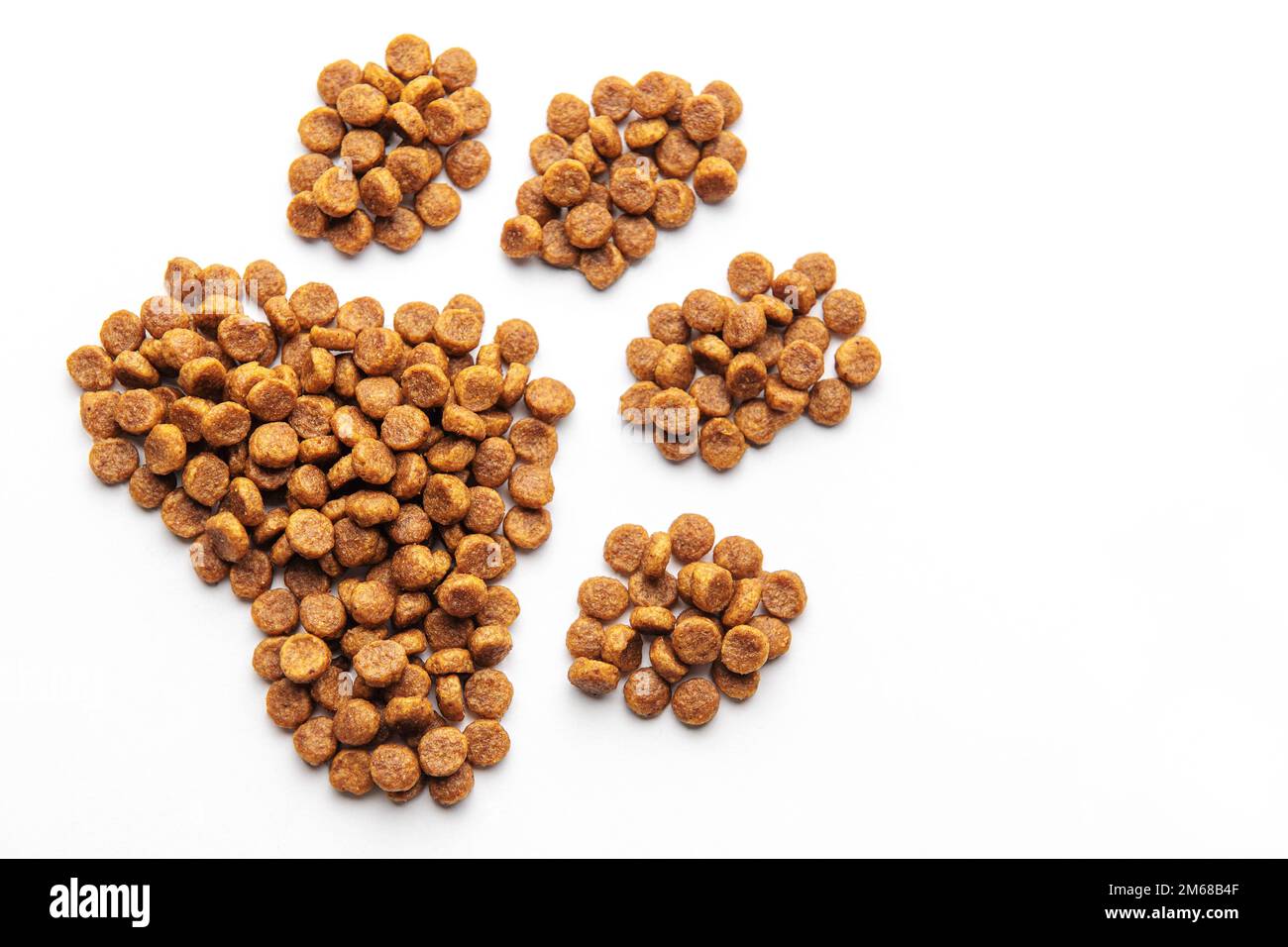 A dog's paw print consists of dog food pellets on a white background ...