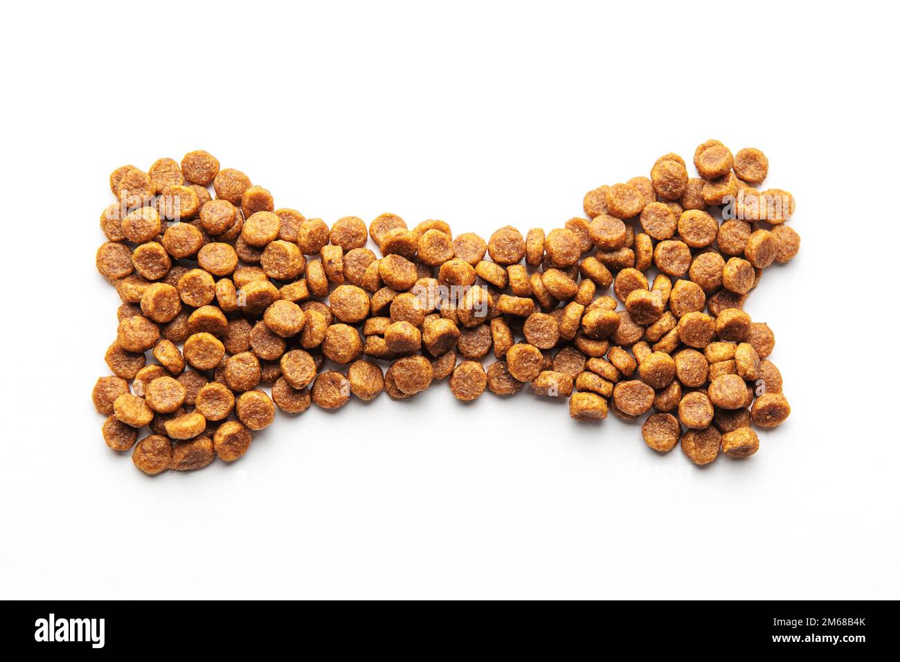 A bone shape consisting of dog food pellets on a white background ...