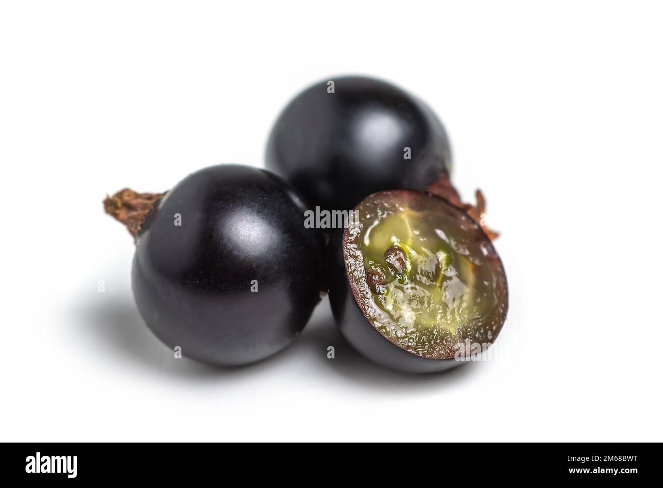Group of black currants, one sliced in half close up Stock Photo - Alamy