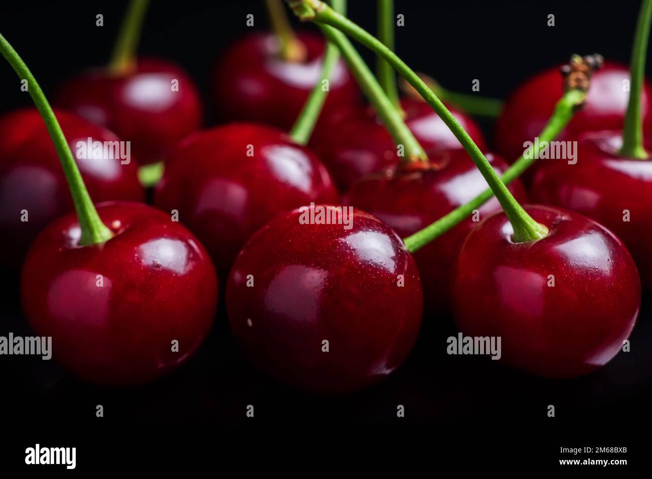 Red cherry berries on a black background with mirror. Three cherries ...